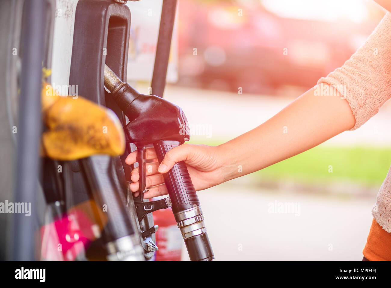 Closeup of woman hand holding a fuel pump at a station Stock Photo - Alamy