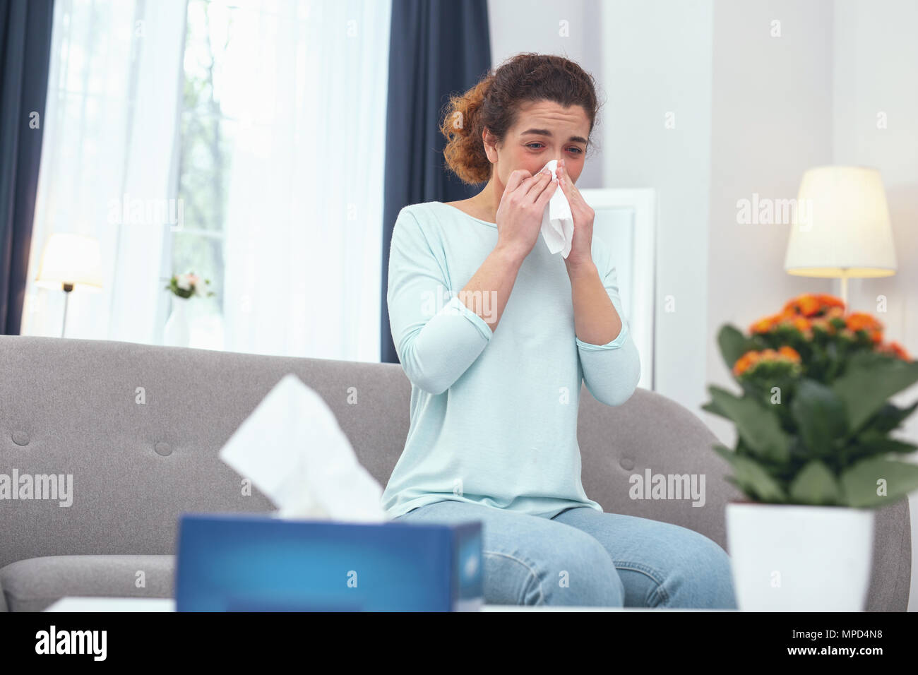 Adolescent lady with influenza blowing her nose Stock Photo - Alamy