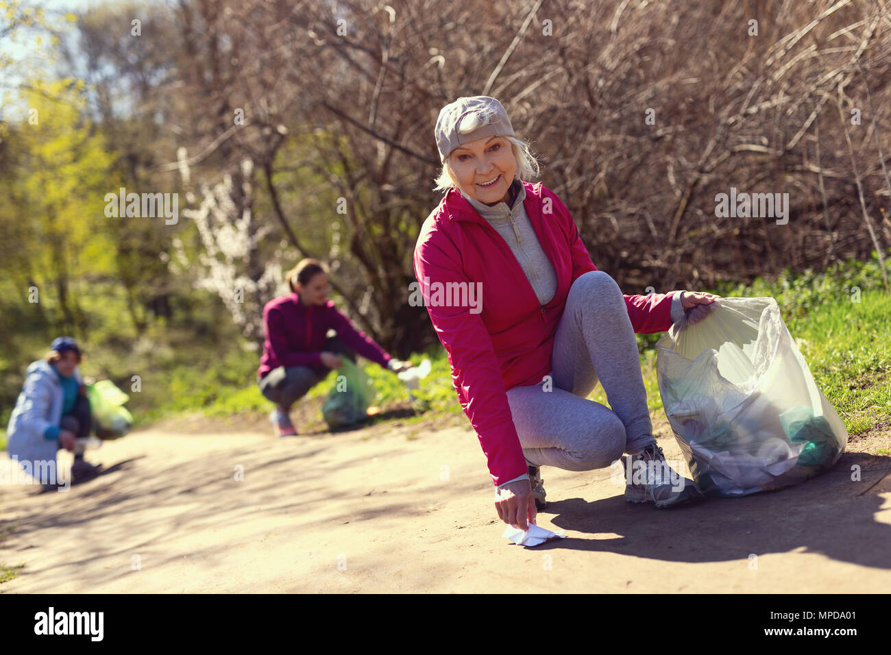 Content woman gathering garbage with her friends Stock Photo - Alamy