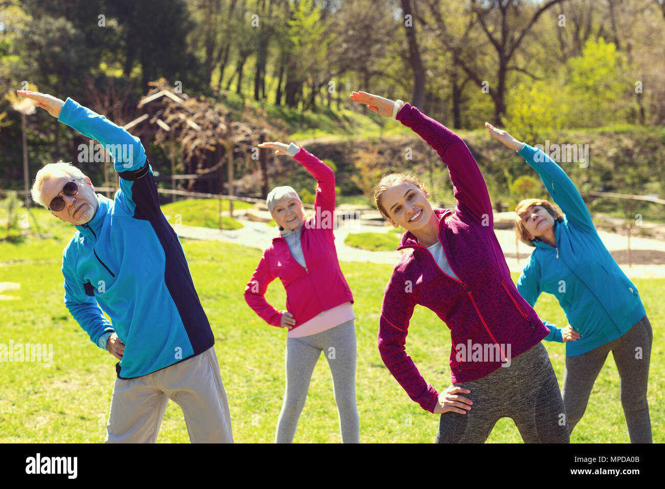 Smiling people doing exercises in the park Stock Photo - Alamy
