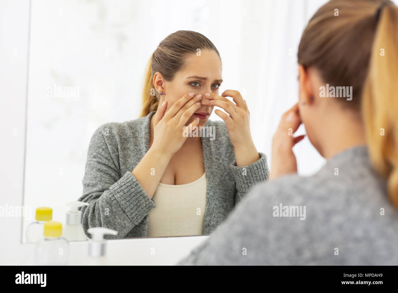 Attractive earnest woman squeezing out pimple Stock Photo - Alamy