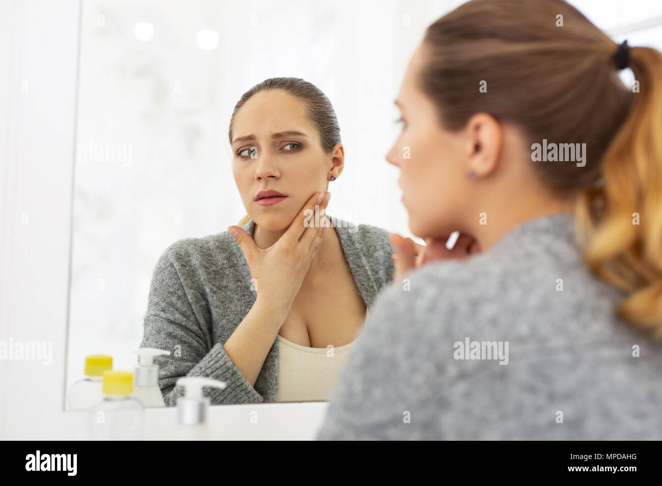 Sad attractive woman scrutinizing her face Stock Photo - Alamy