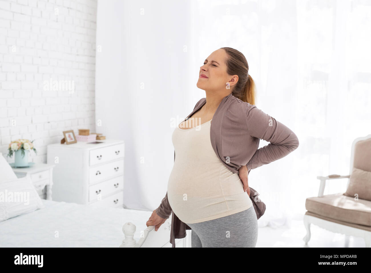 Dismal pregnant woman relieving back pain Stock Photo - Alamy Dismal pregnant woman relieving back pain Stock Photo - Alamy