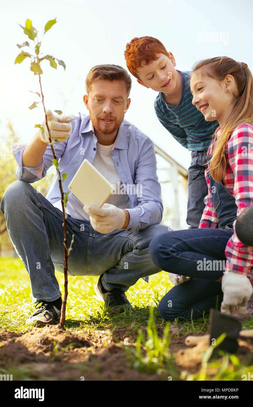 Nice handsome man pointing at the tree Stock Photo - Alamy