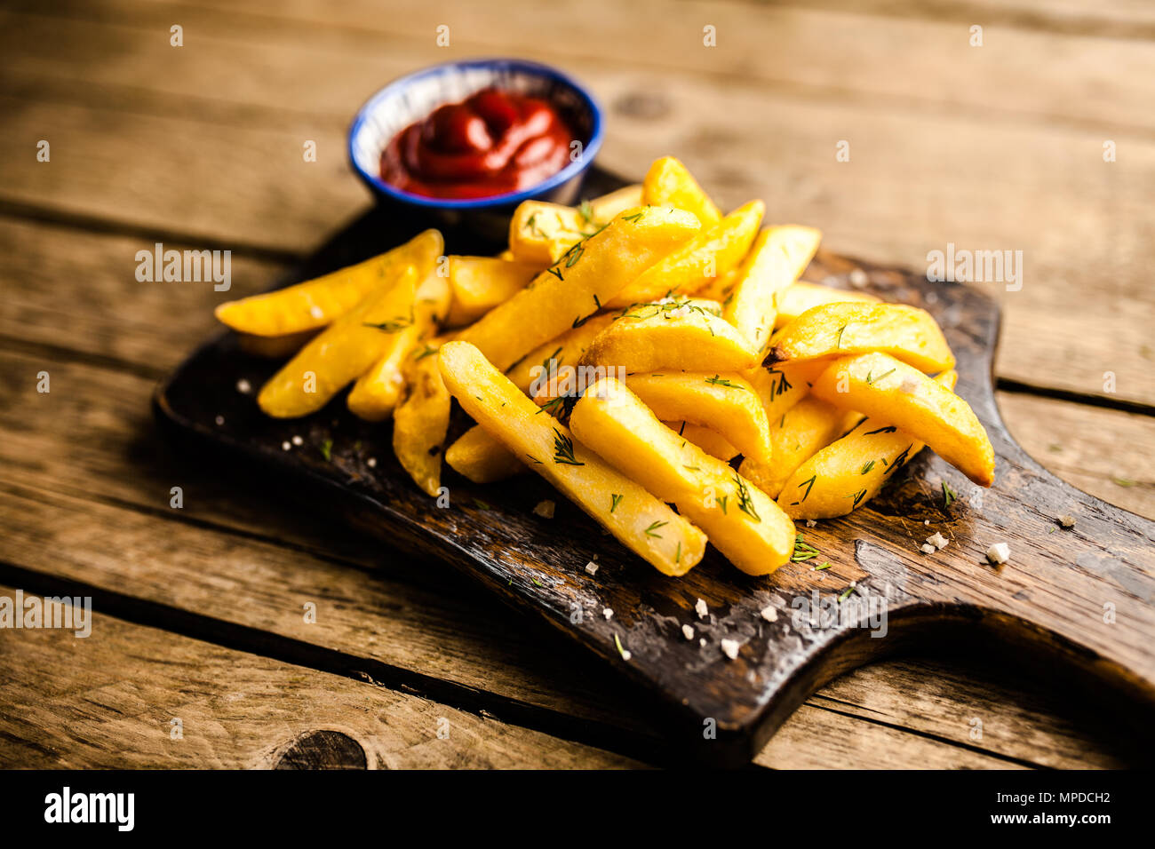 French fries on wooden table Stock Photo - Alamy