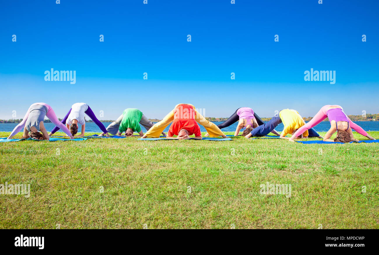 Young people practice Yoga asana on lakeside. Yoga concept Stock Photo ...