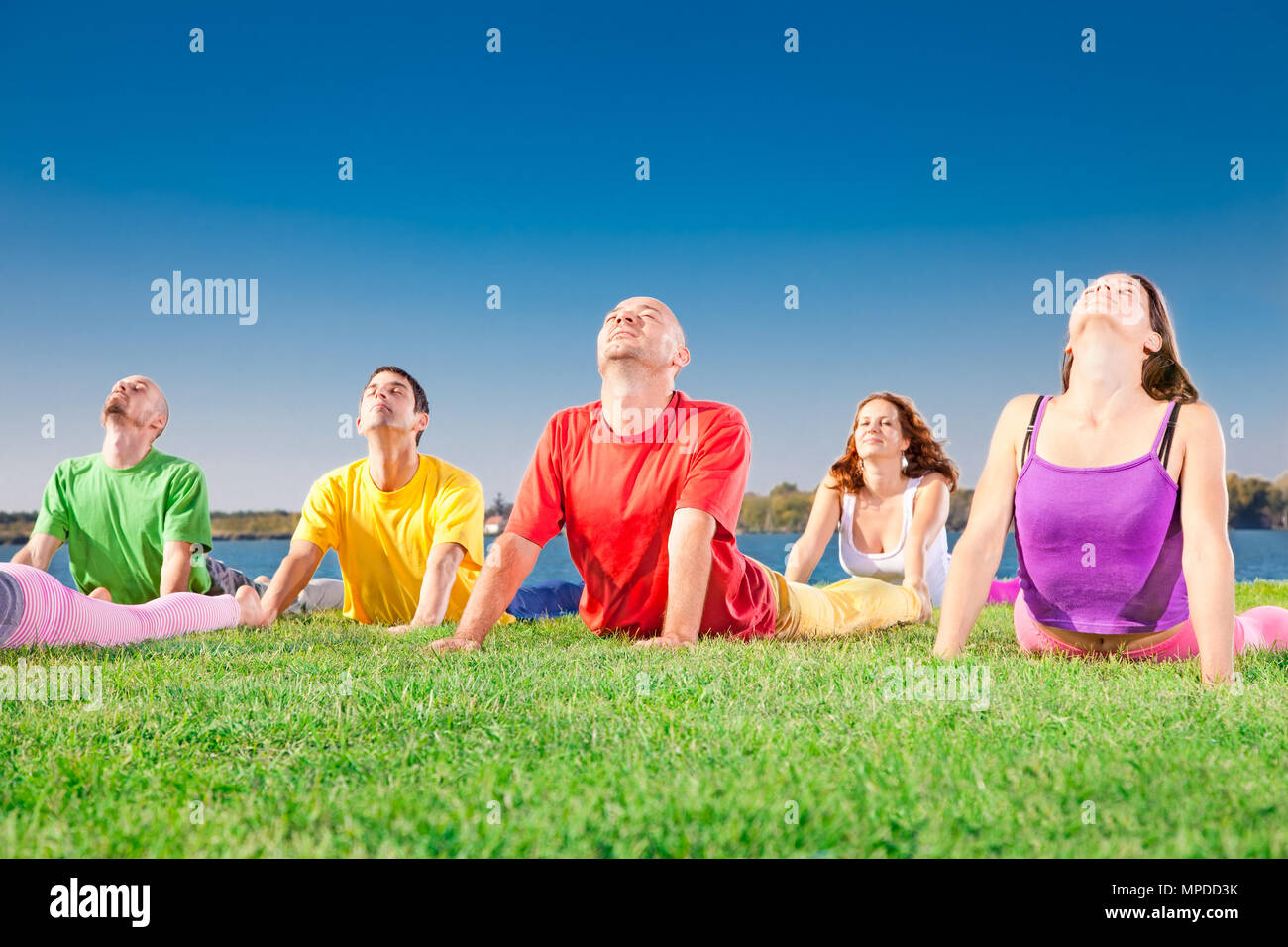 Young people practice Yoga asana on lakeside. Yoga concept Stock Photo ...