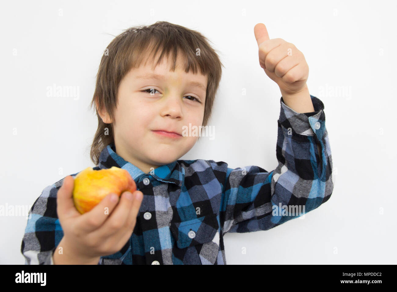 Smiling five-year boy with bitten apple in his hand with other hand ...