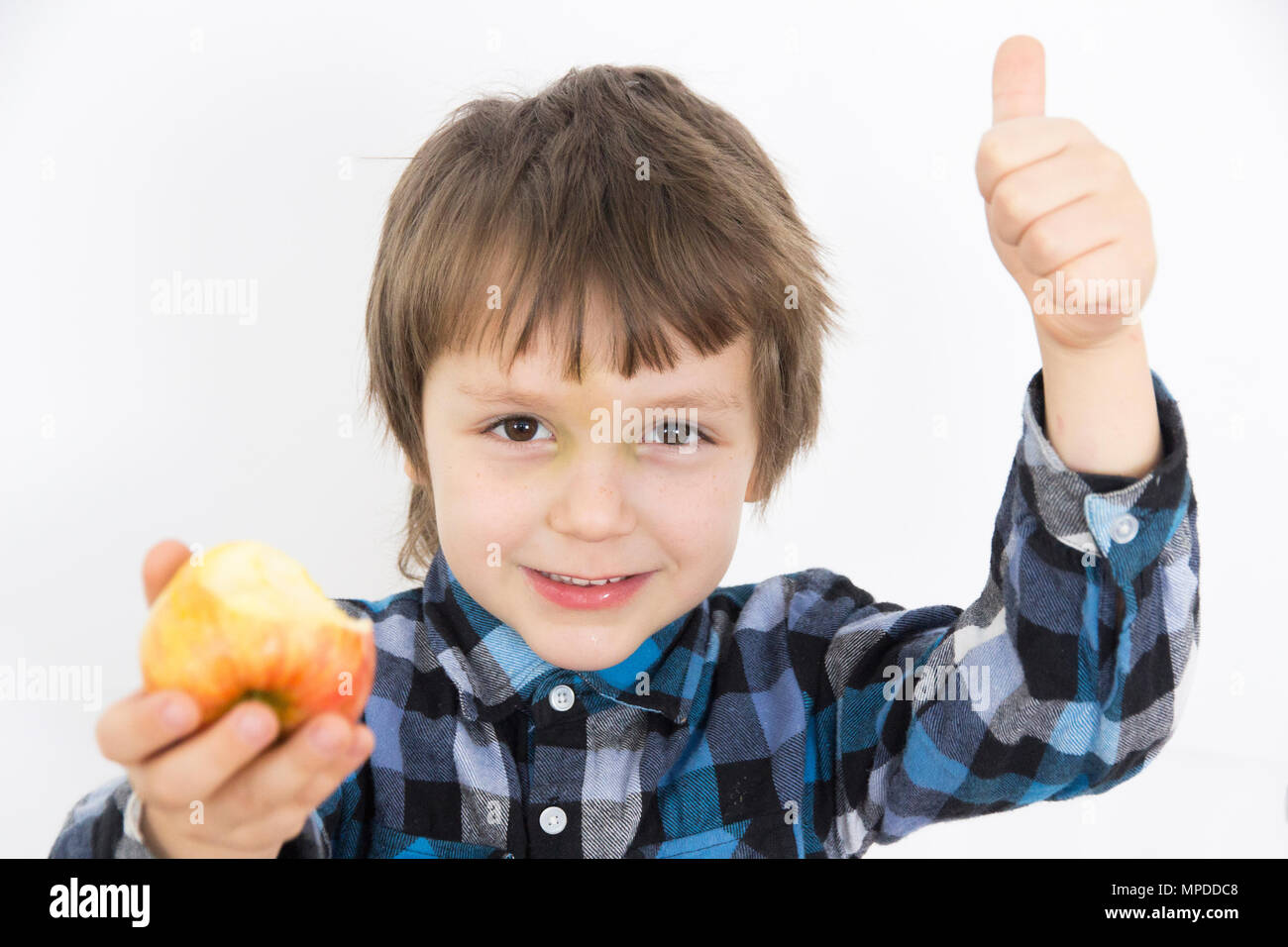 Smiling five-year boy with bitten apple in his hand with other hand ...