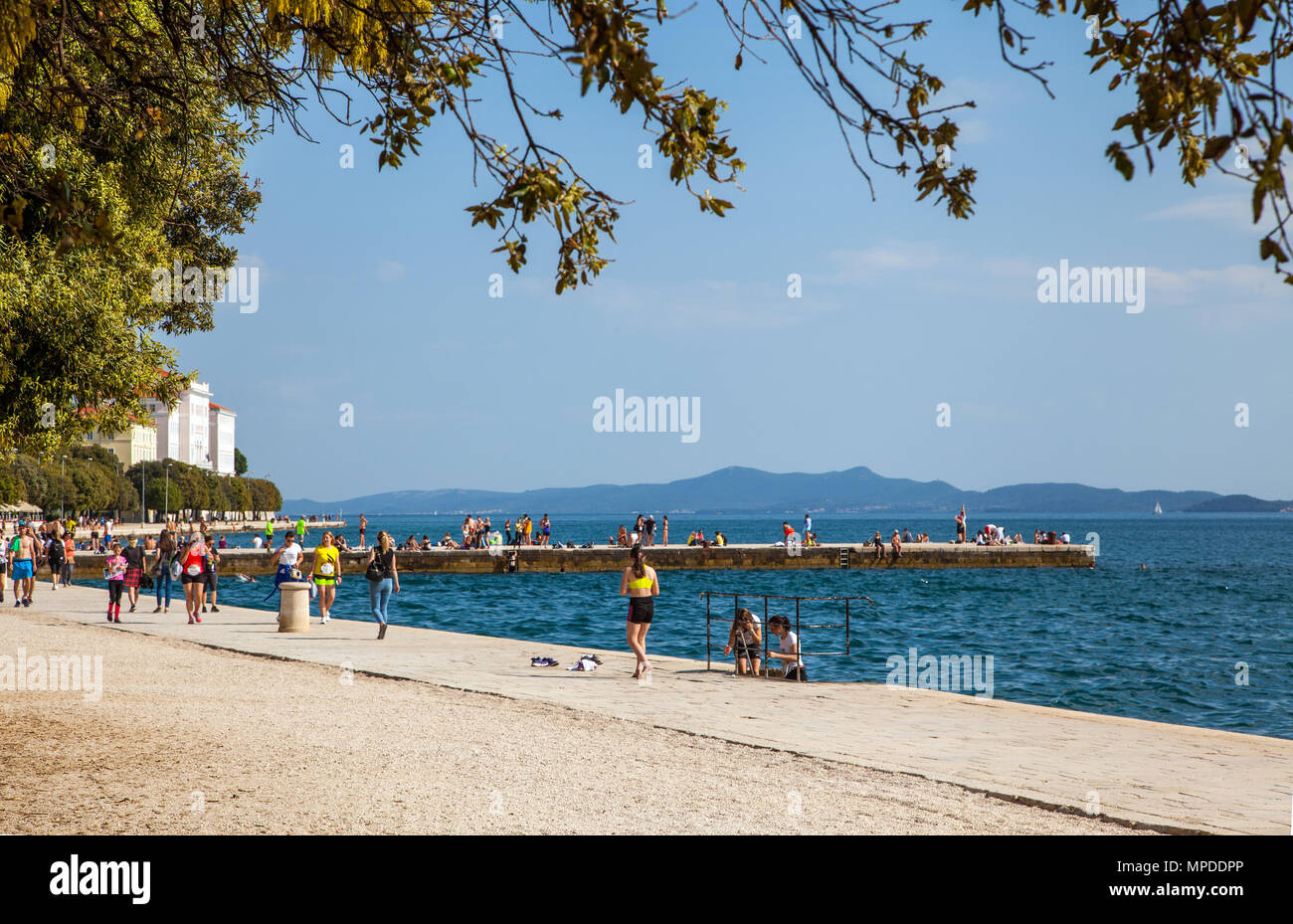 People enjoying the sunshine on the promenade and pier / jetty in the ...