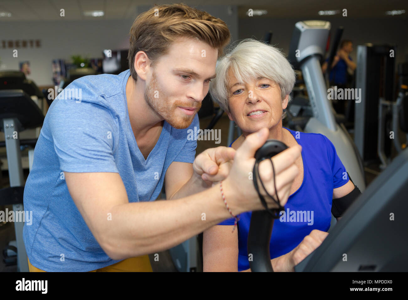 coach showing the old woman her exercise result Stock Photo - Alamy