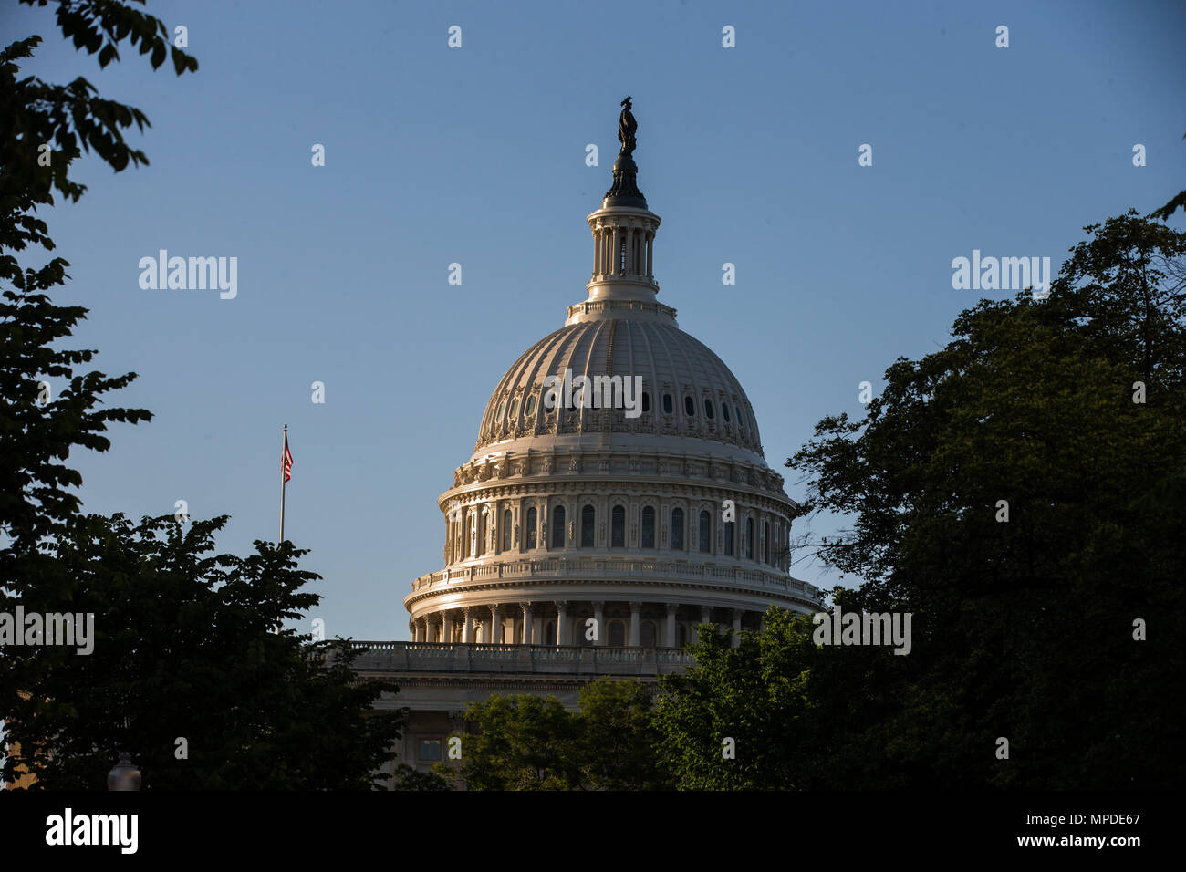 Sunlight illuminates the west face of the the U.S. Capitol prior to ...