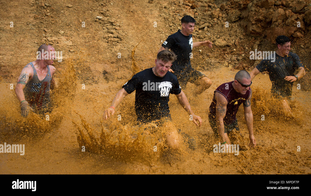 Marines slide down a muddy slope during the Camp Hansen World Famous ...