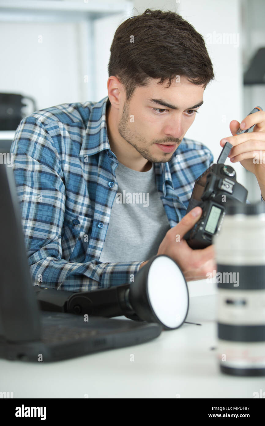young man fixing camera Stock Photo - Alamy