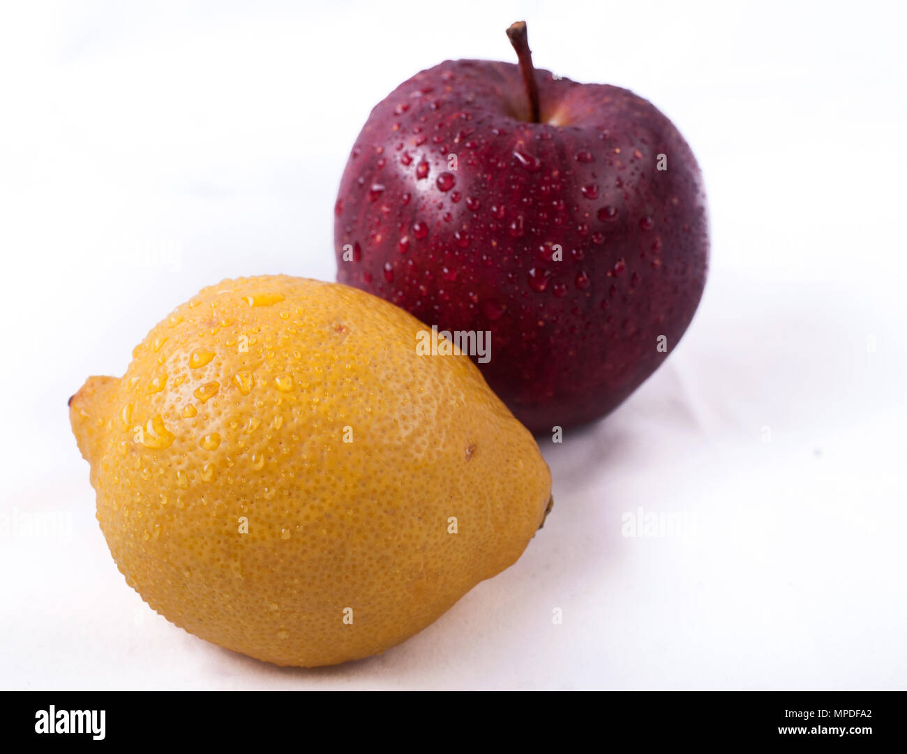 Yellow lemon and red apple on a white background Stock Photo - Alamy