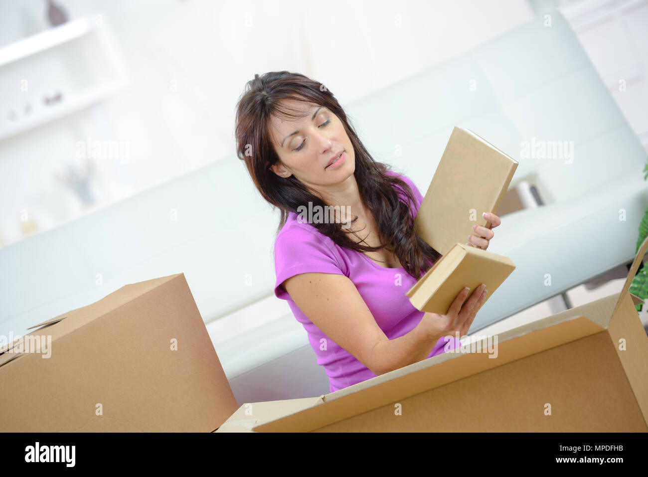 Woman packing books box hi-res stock photography and images - Alamy
