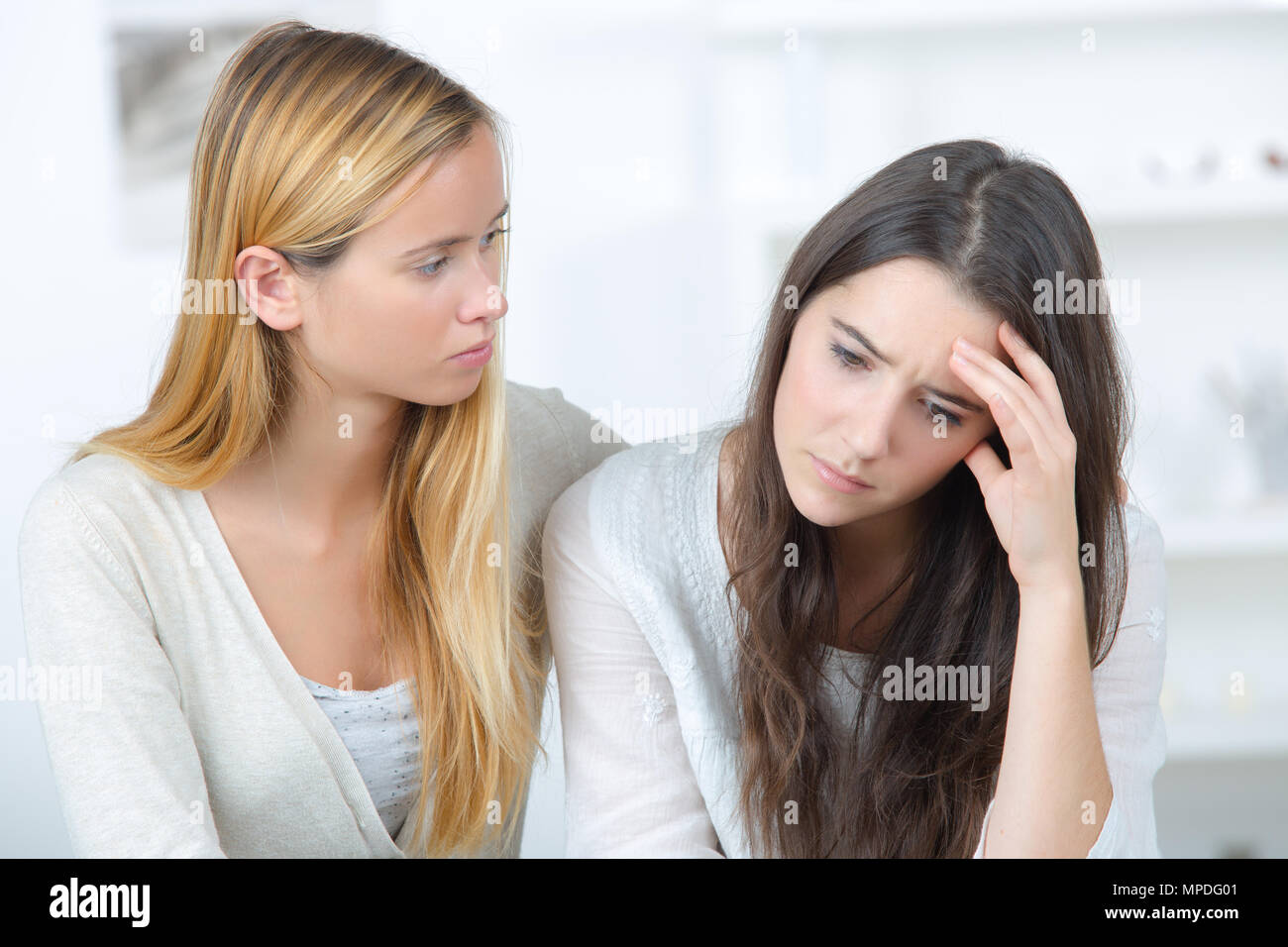 depressed teenage girl while her close girlfriend is comforting her ...