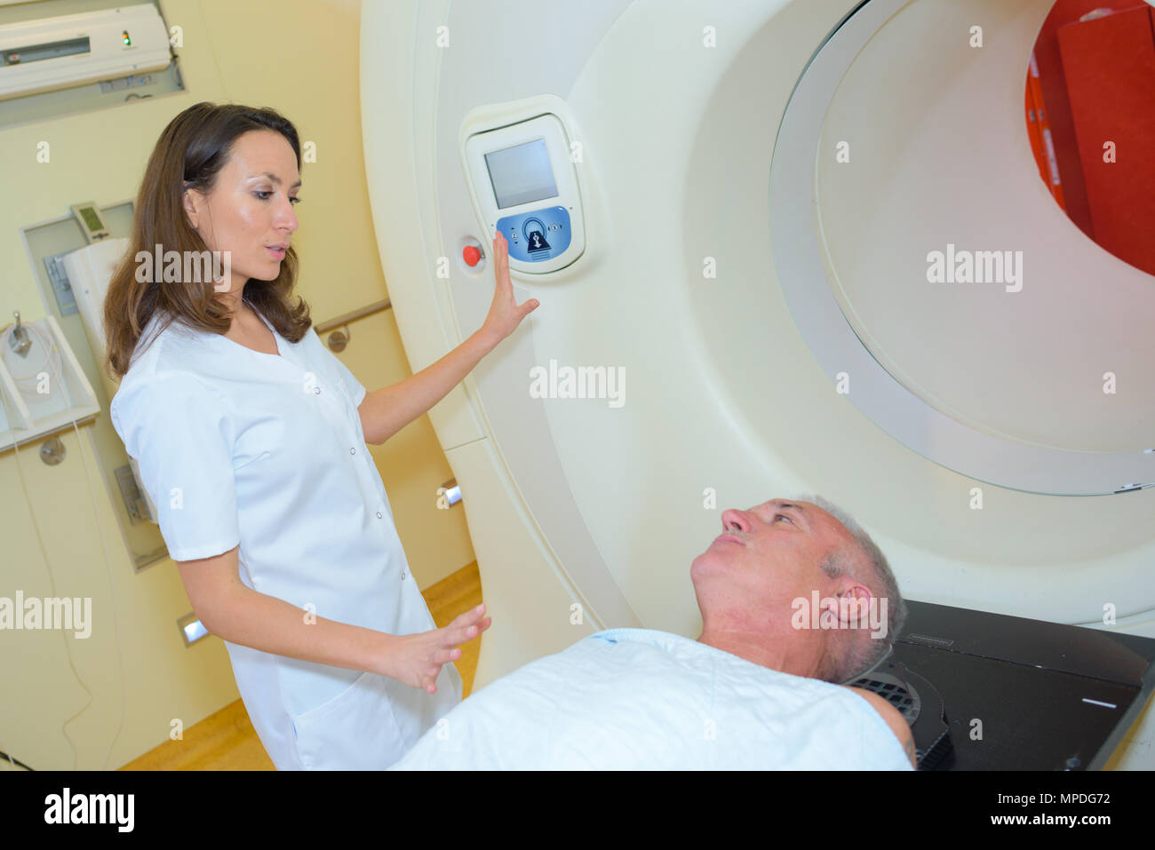 Nurse talking to patient entering scanner Stock Photo - Alamy
