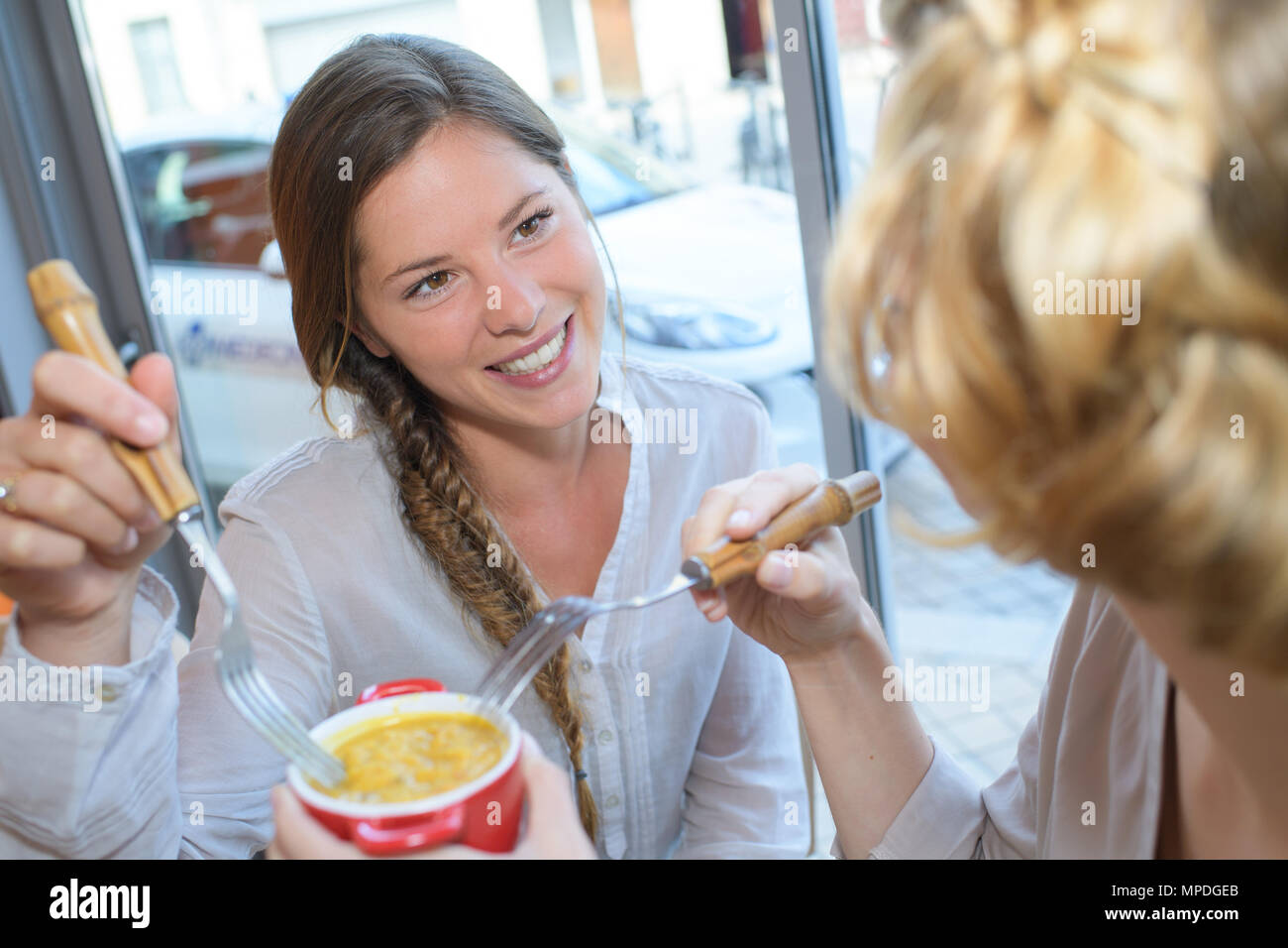 two beautiful friends eating in a restaurant Stock Photo - Alamy