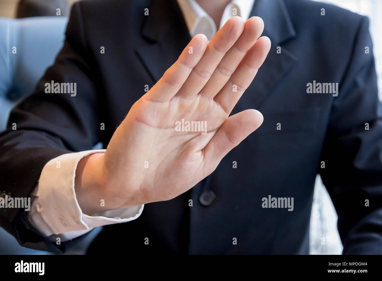Young man in business suit in cafe shows hand stop sign Stock Photo - Alamy