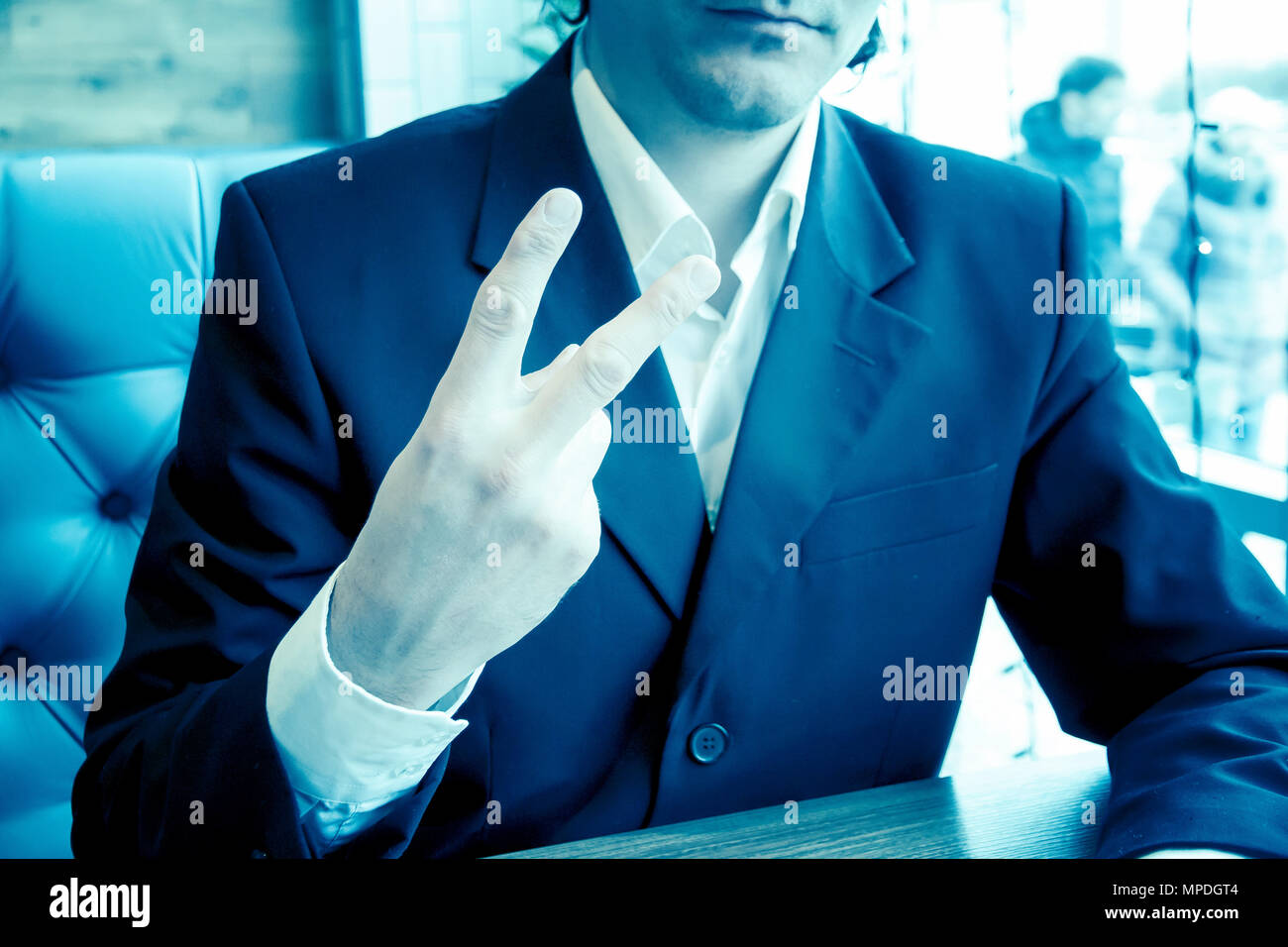 Men's hand showing victory sign Stock Photo - Alamy