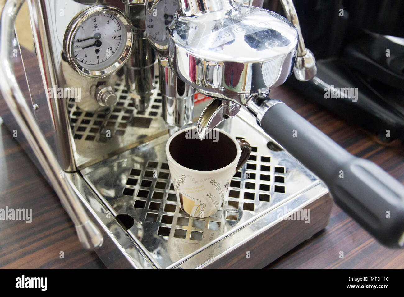 Modern metal coffee machine stands empty coffee cup Stock Photo - Alamy