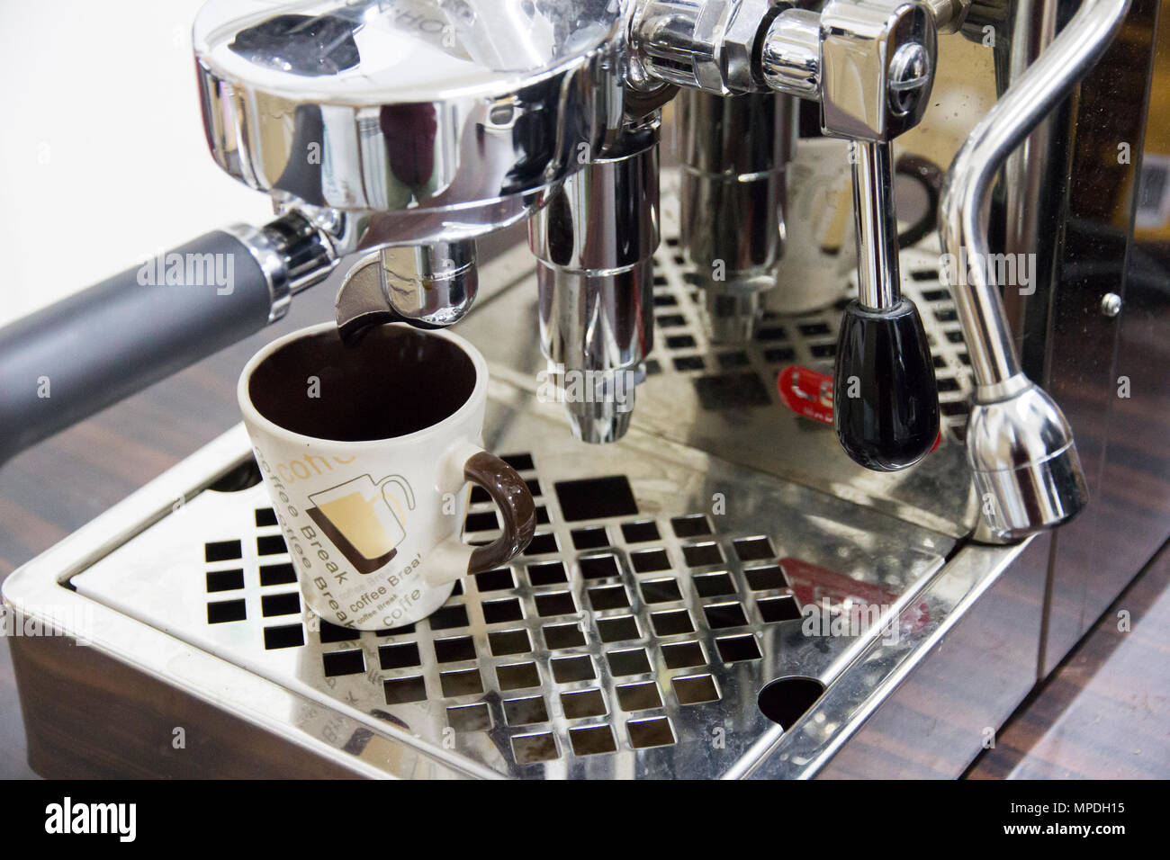 Modern metal coffee machine stands empty coffee cup Stock Photo - Alamy