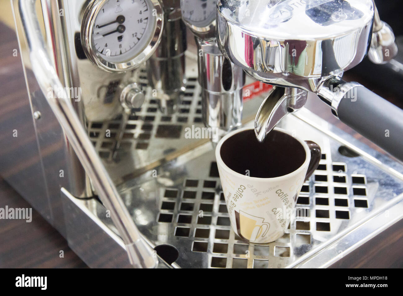 Modern metal coffee machine stands empty coffee cup Stock Photo - Alamy