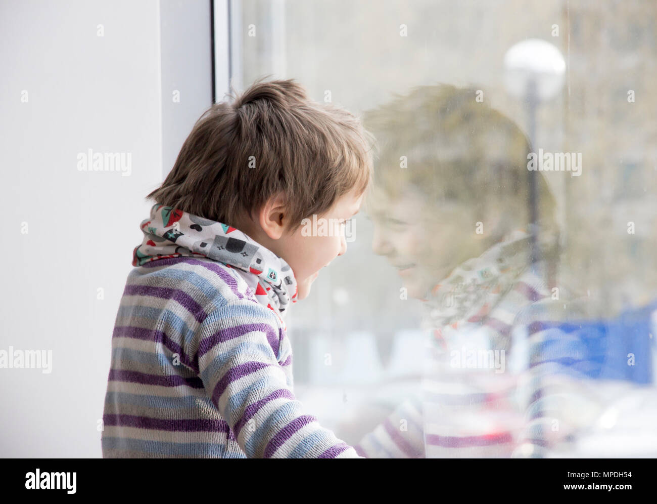 Handsome boy smiling to someone in window Stock Photo - Alamy