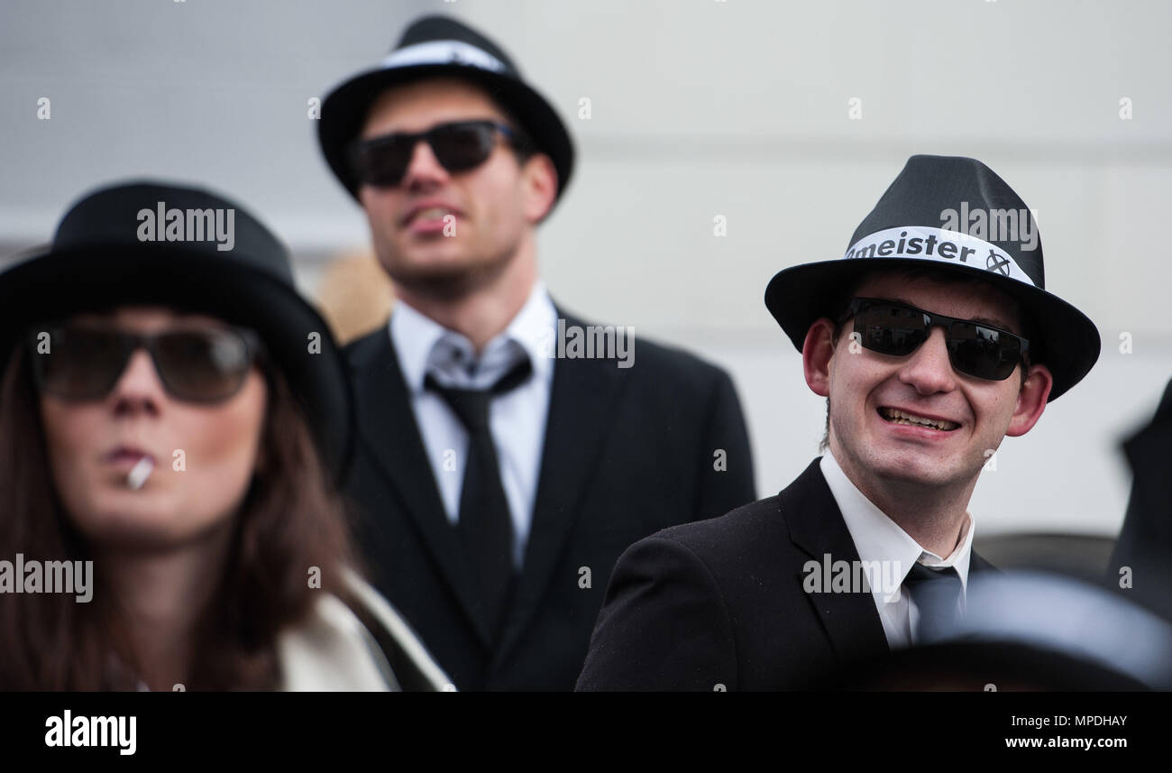 Members of a parade group called “Men in Black” walk through a parade ...