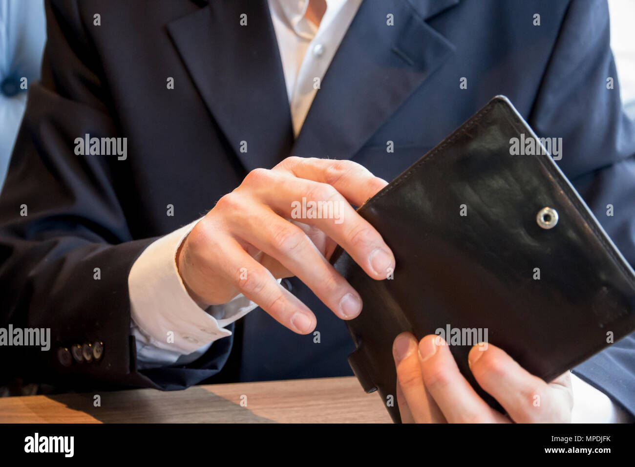 Man in business suit in cafe opened black leather purse Stock Photo - Alamy