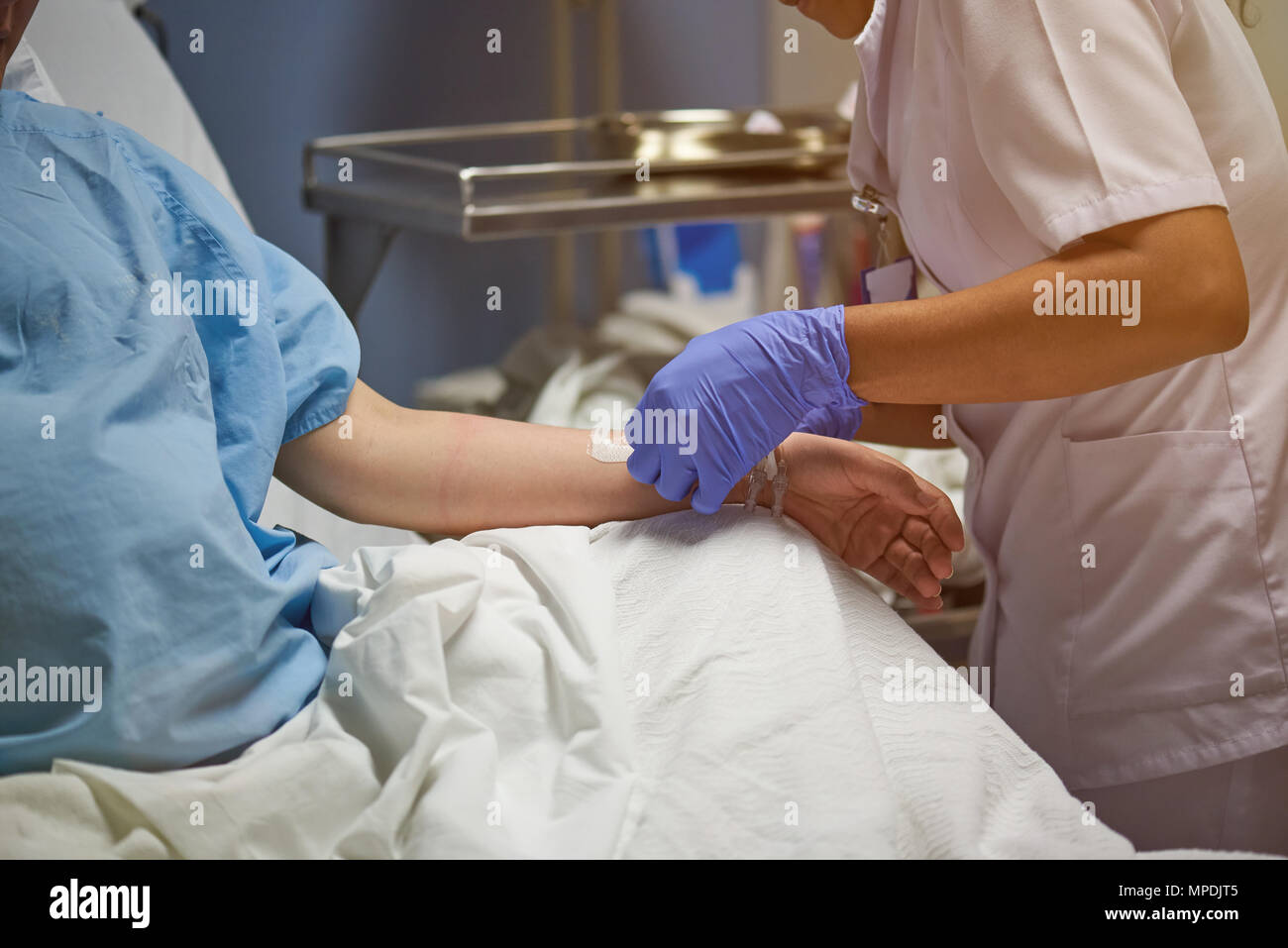 Nurse injecting catheter in hand of patient close up Stock Photo - Alamy