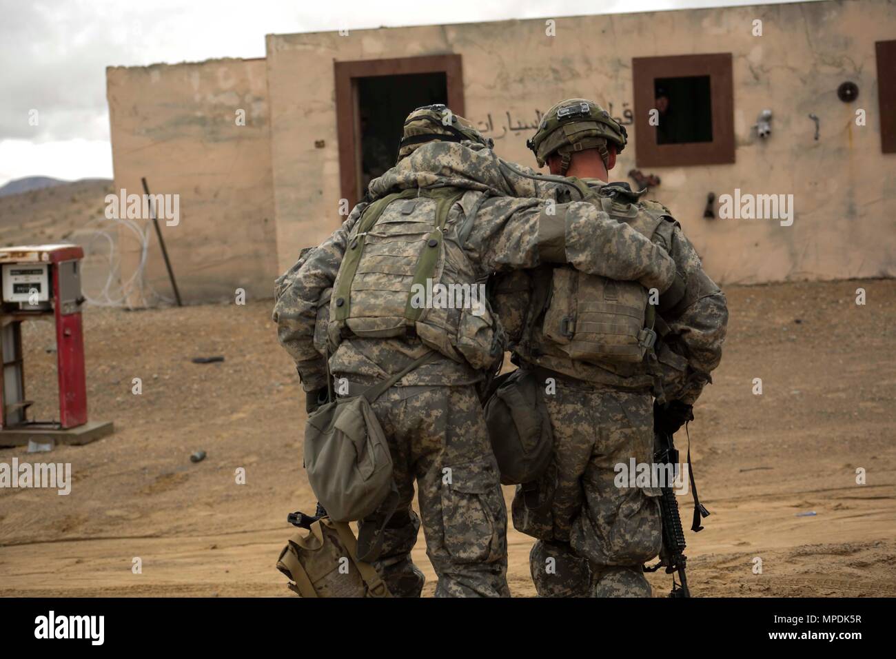 A U.S. Soldier, assigned to 2nd Brigade, 1st Cavalry Division, helps a ...