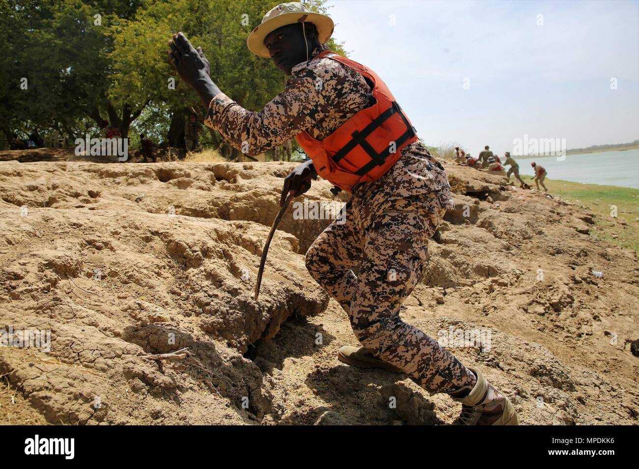 A Chadian Army soldier gives hand and arms signals to form a wedge ...