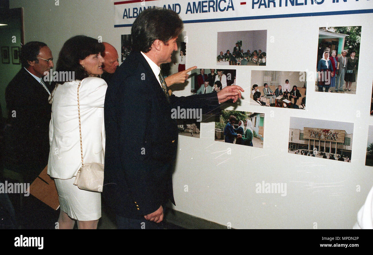 MEN AND WOMAN LOOKING AT POSTER Stock Photo - Alamy