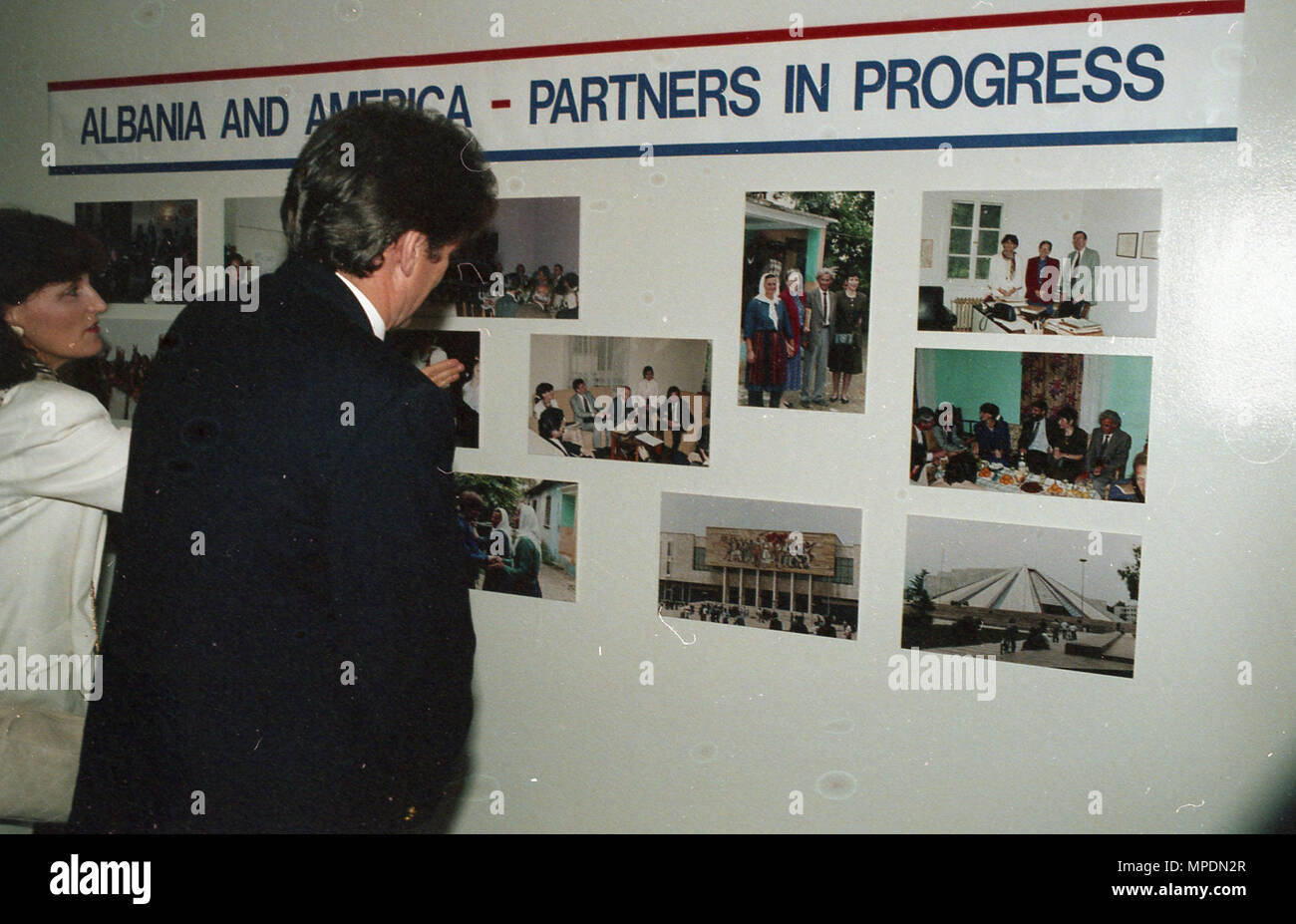 MAN AND WOMAN LOOKING AT POSTER Stock Photo - Alamy