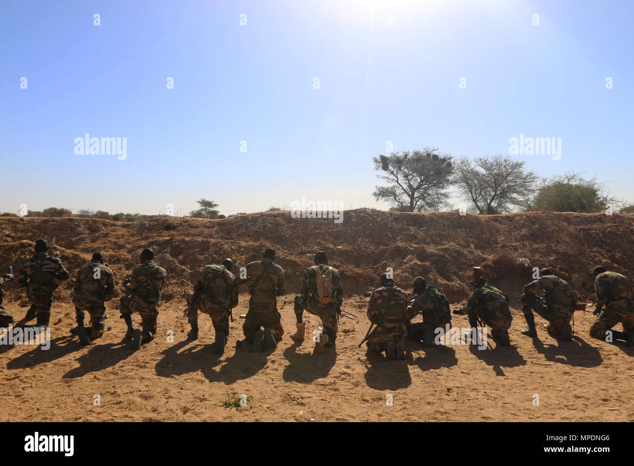 A squad of Nigerien soldiers loads ammunition in preparation for ...