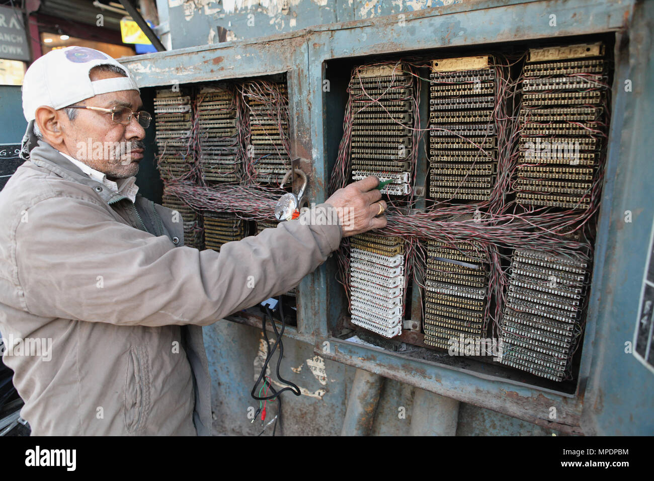 India, New Delhi, An electrician working on a fuse box in Chandni Chowk ...