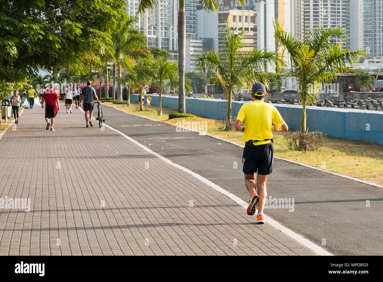 people running in public park with city skyline in background, Panama ...
