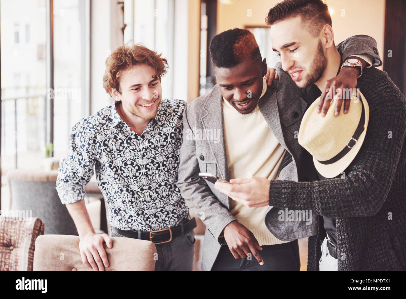 Cheerful old friends communicate with each other and phone watch in pub ...