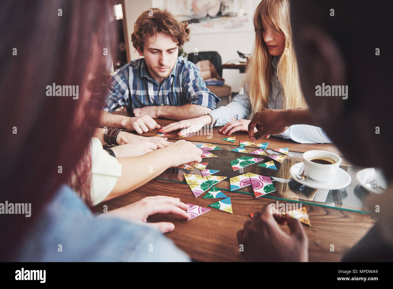 Group of creative friends sitting at wooden table. People having fun ...
