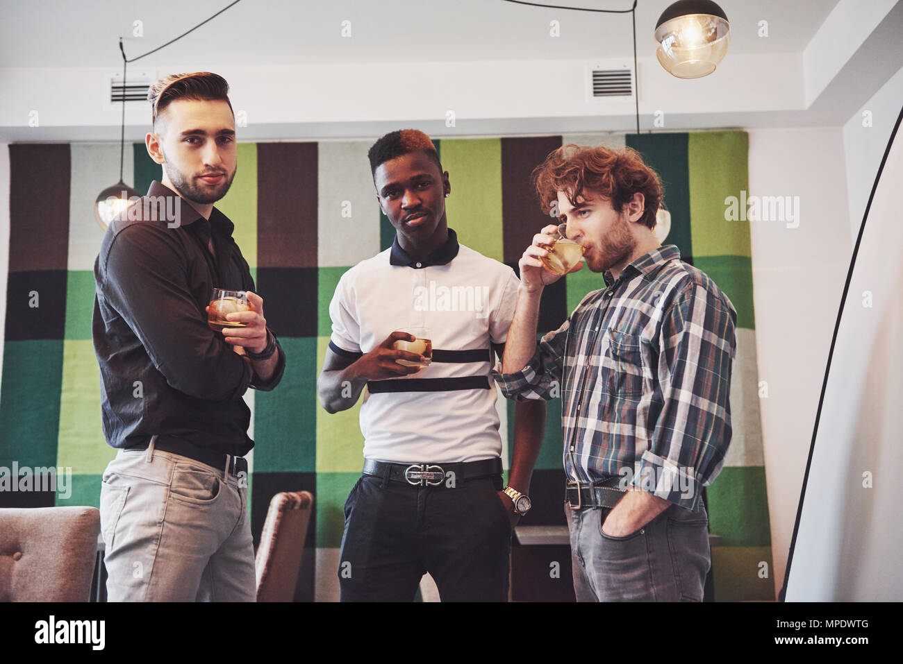 promising young multi ethnic people celebrating and drinking whiskey ...