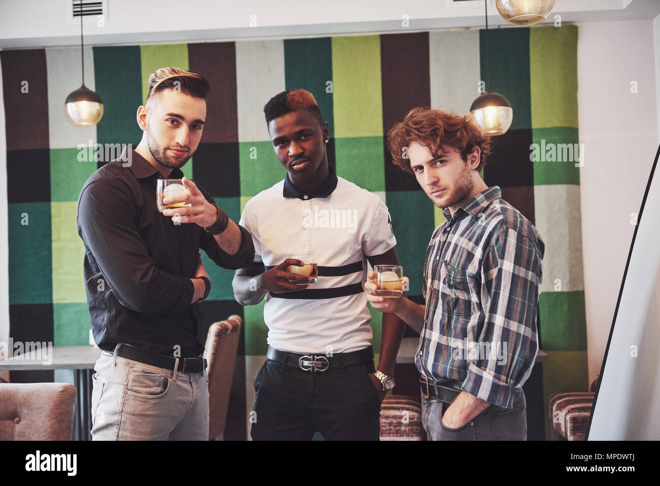 promising young multi ethnic people celebrating and drinking whiskey ...