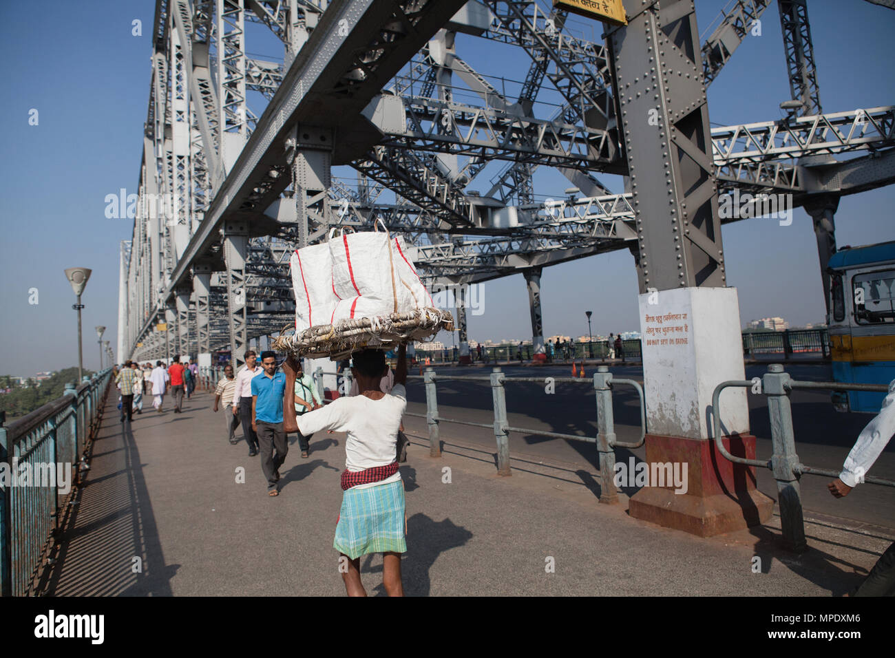 India, West Bengal, Kolkata, Howrah Bridge, Man carrying goods on his ...