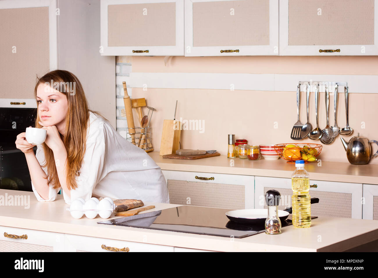 Girl thinking drinking tea in the kitchen Stock Photo - Alamy