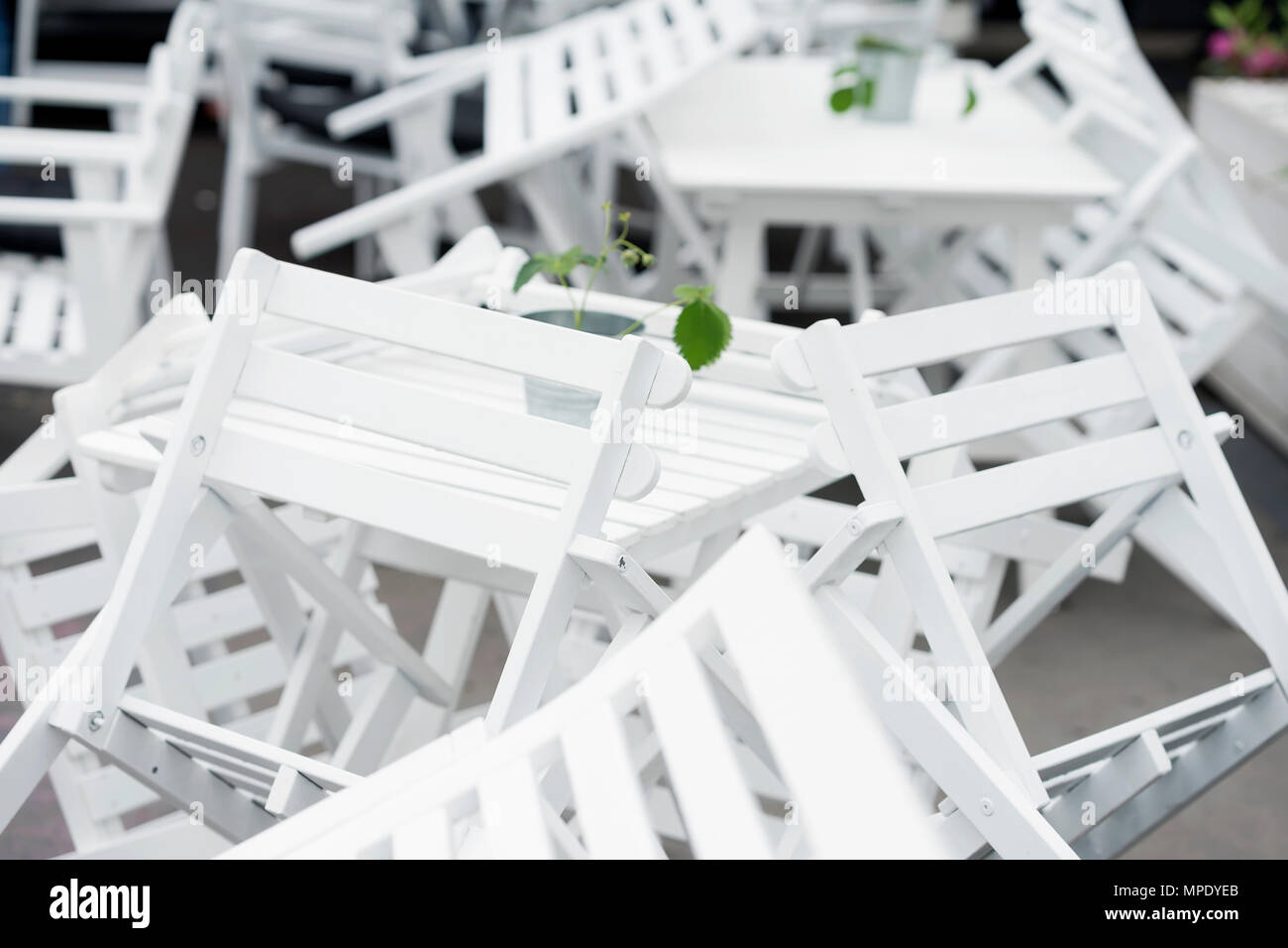 Many of inverted white plastic chairs on tables in closed restaurant on ...