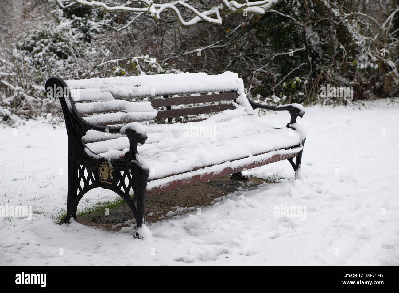 park bench covered in snow in London Stock Photo - Alamy