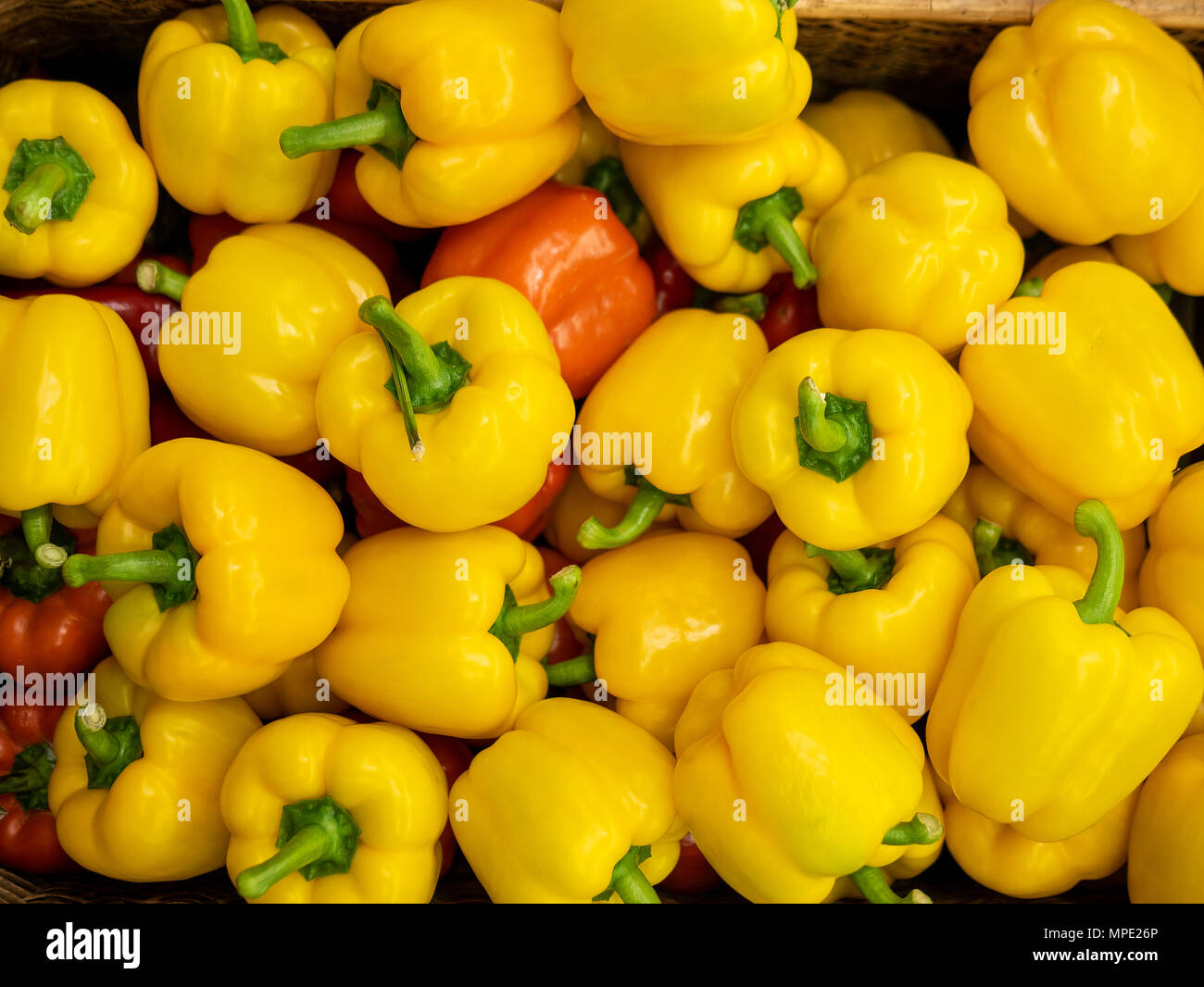 Yellow pepper close up on a market. Landscape. A backdrop of stacked ...
