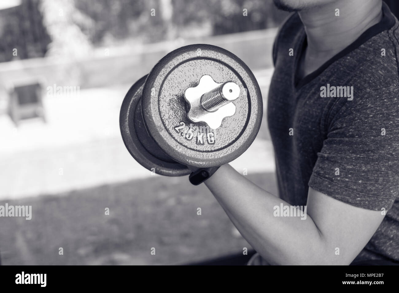 man hand lifting the steel dumbbell in a gym musclebuilding black and ...