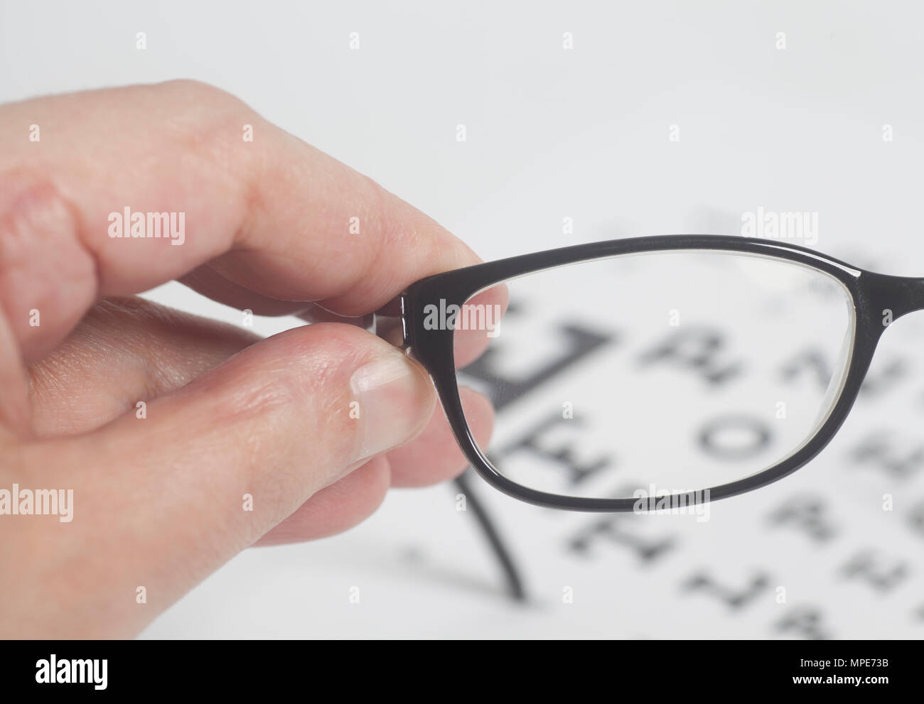 Male hand holding black Eyeglasses for vision eyesight examination test ...